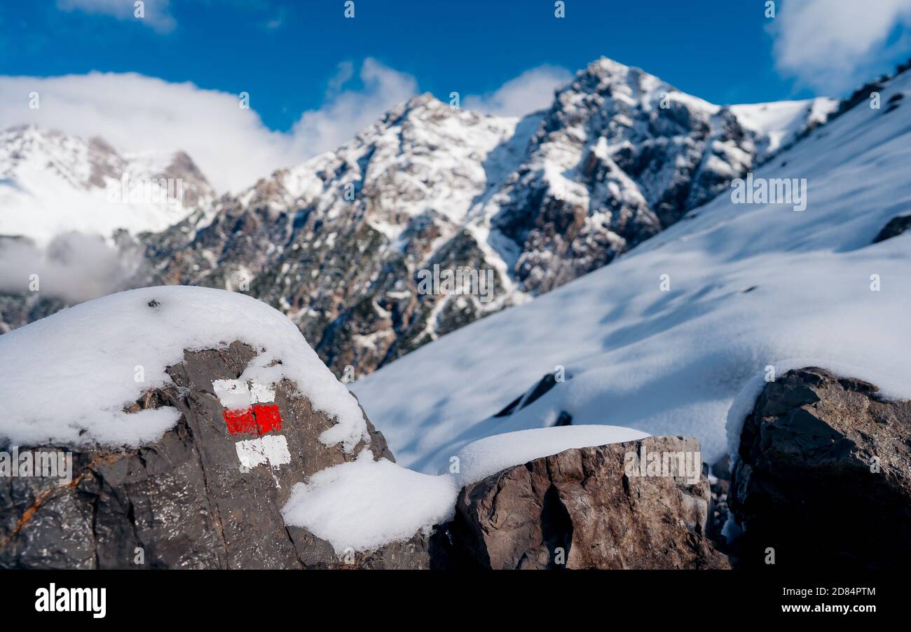 Trail marker in the mountains on the hiking trail. White and red way ...