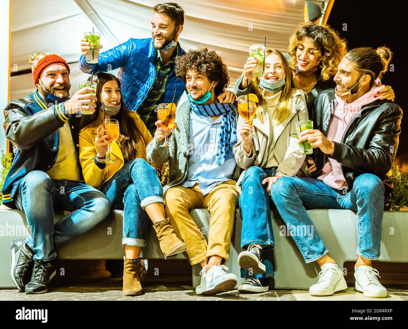 Fashion trendy friends with face mask drinking cocktails outside bar ...