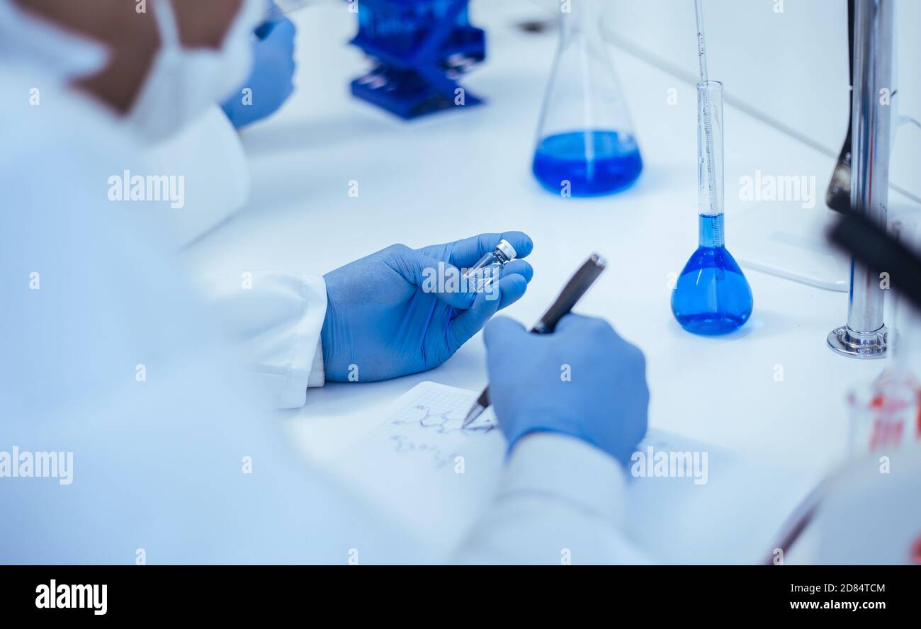 rear view. scientist recording the results of investigations in a ...