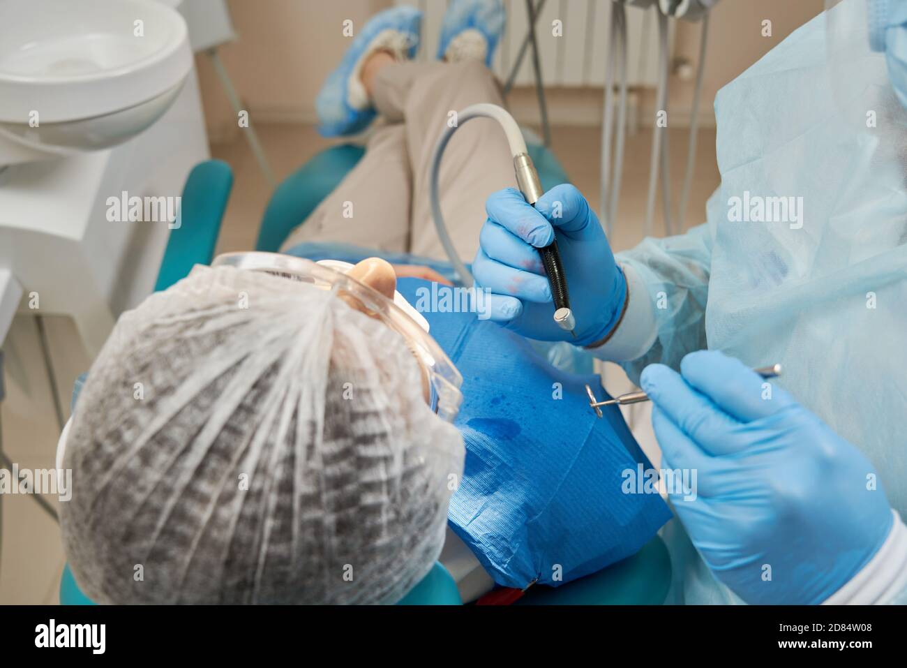 dentist drilling tooth to male patient in dental chair Stock Photo - Alamy