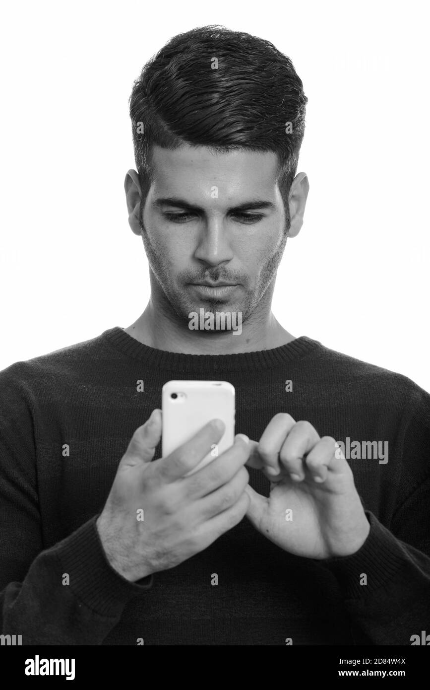 Face of young handsome Persian man using mobile phone touching the ...