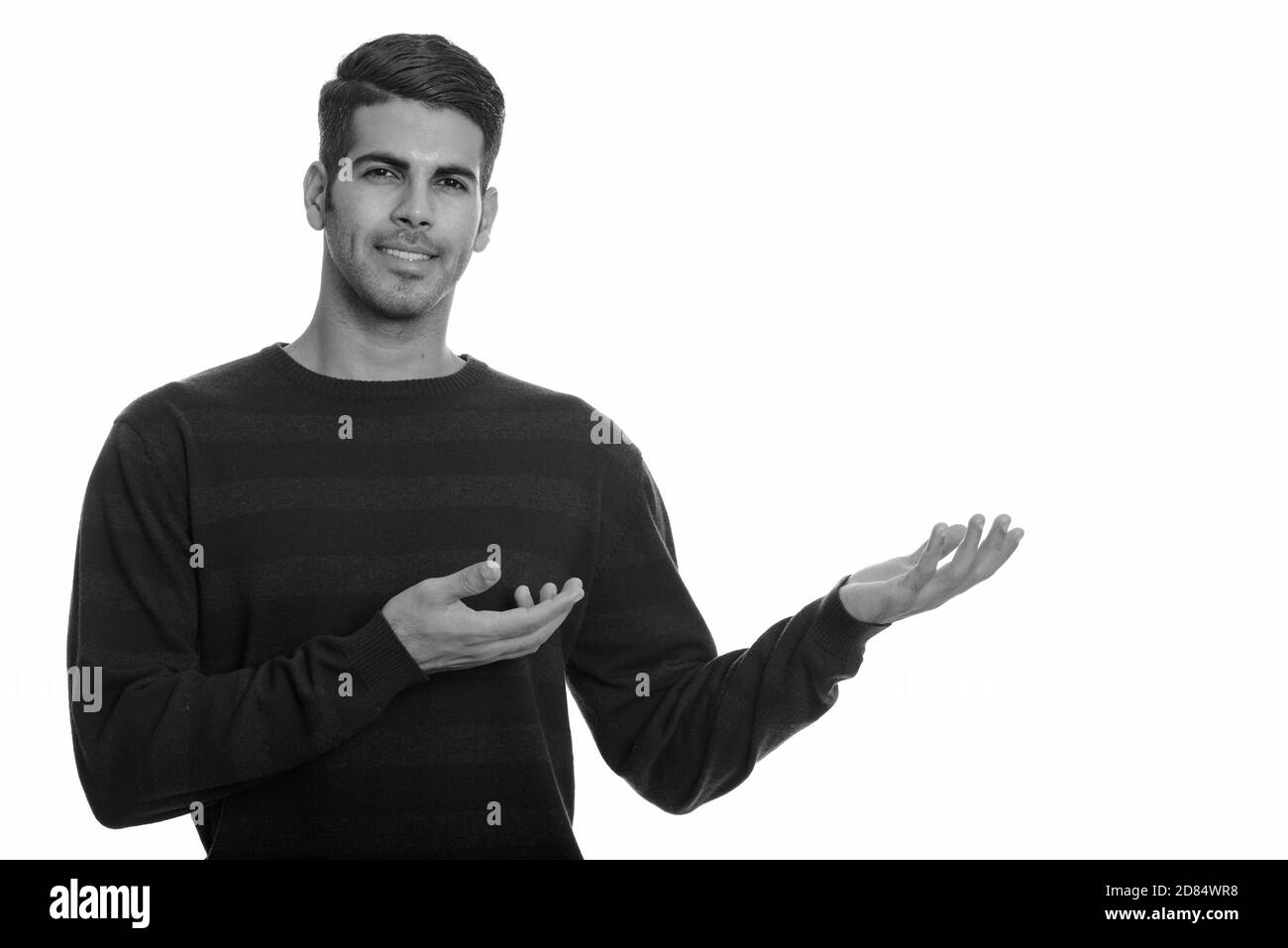 Young happy Persian man smiling and showing something Stock Photo - Alamy