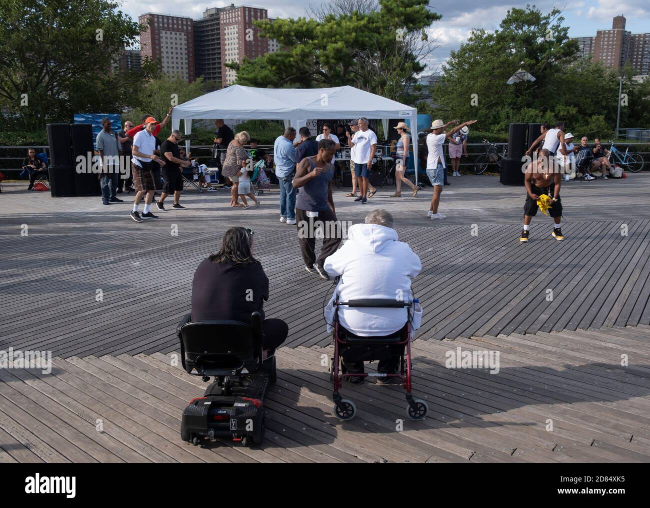 Two disabled people watch the dancers on the Coney Island boardwalk ...