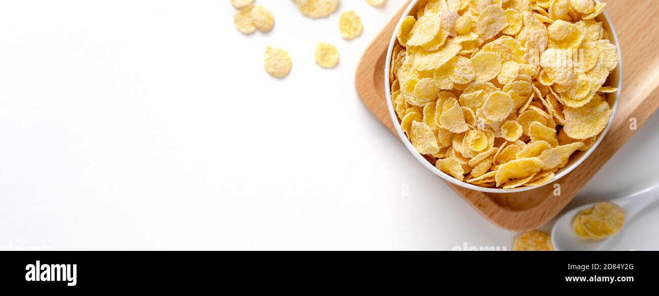 Top view of corn flakes bowl sweeties with milk and orange on white ...