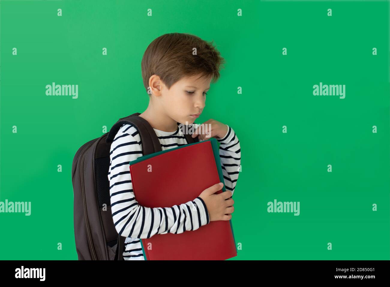 Schoolboy with a bored face with copy space. Pupil with a backpack and ...