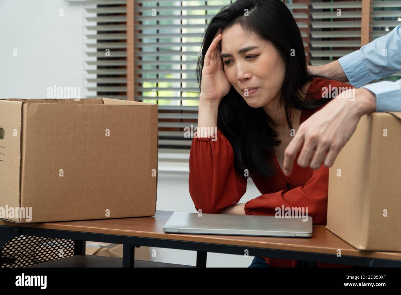 Sad Asian woman Packing belongings in a cardboard box and crying on the ...