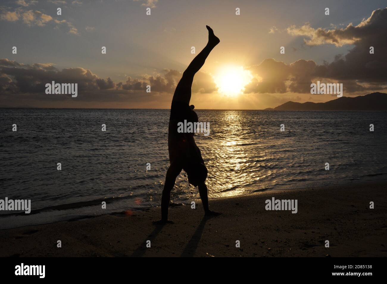 Silhouette Doing Handstand On Beach At Sunset Stock Photo - Alamy