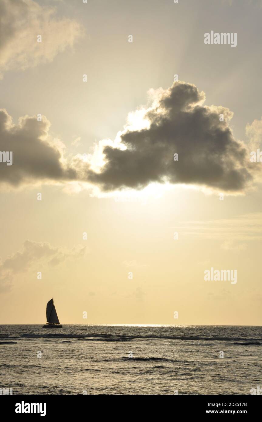 Yellow sunset with cloud in front of the sun and horizon over water ...