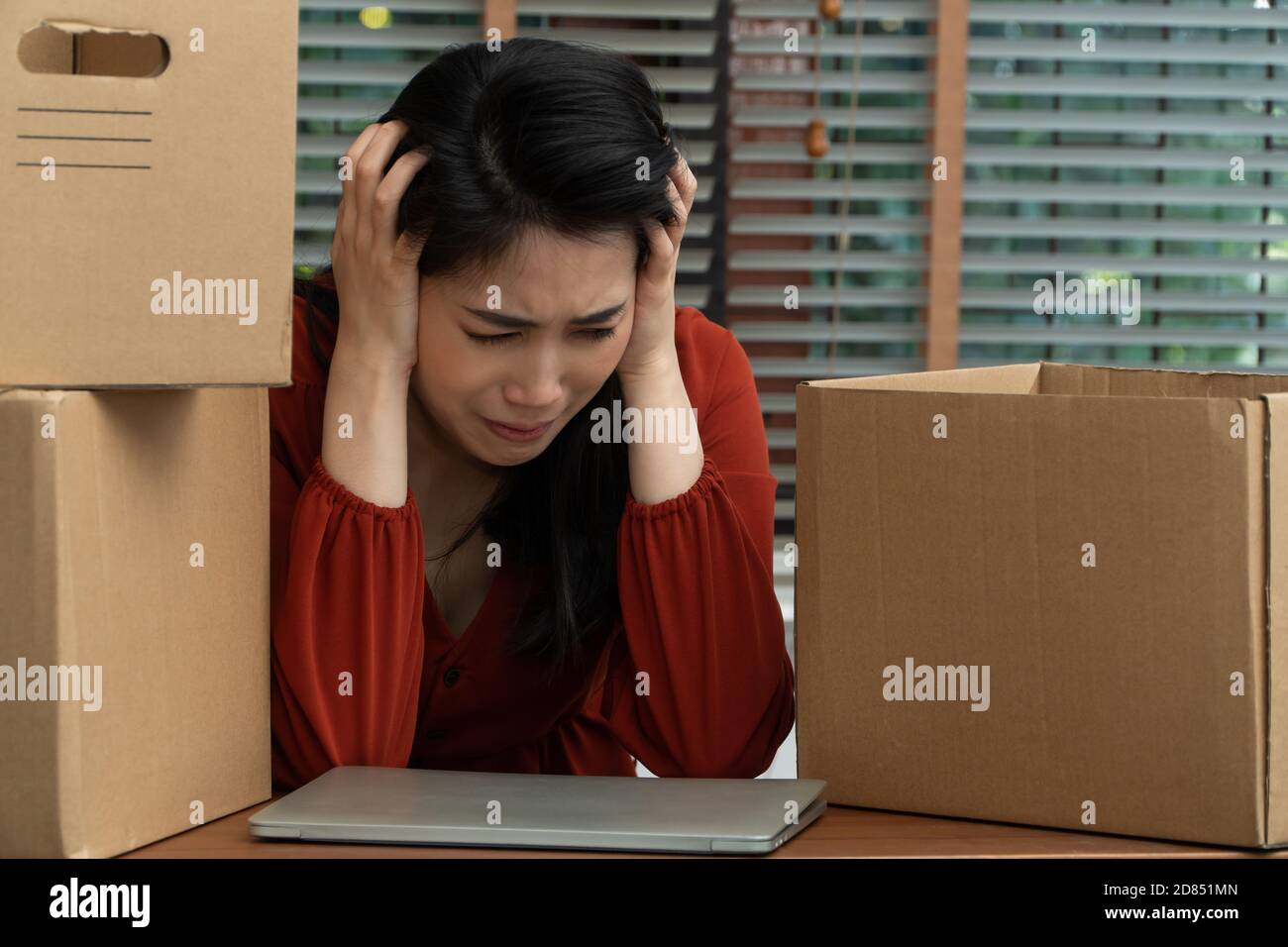 Sad Asian woman Packing belongings in a cardboard box and crying on the ...