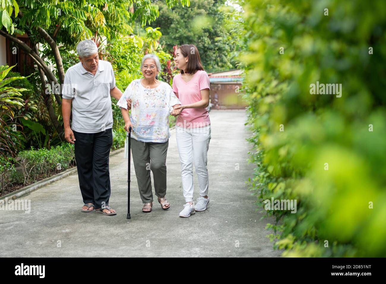 Happy family walking together in the garden. Old elderly using a ...