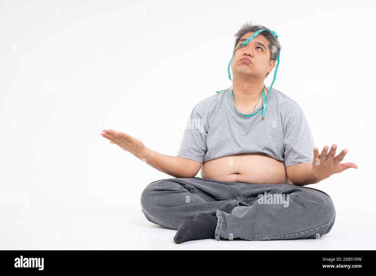 An overweight man sitting on the floor and Bored after uses a ...