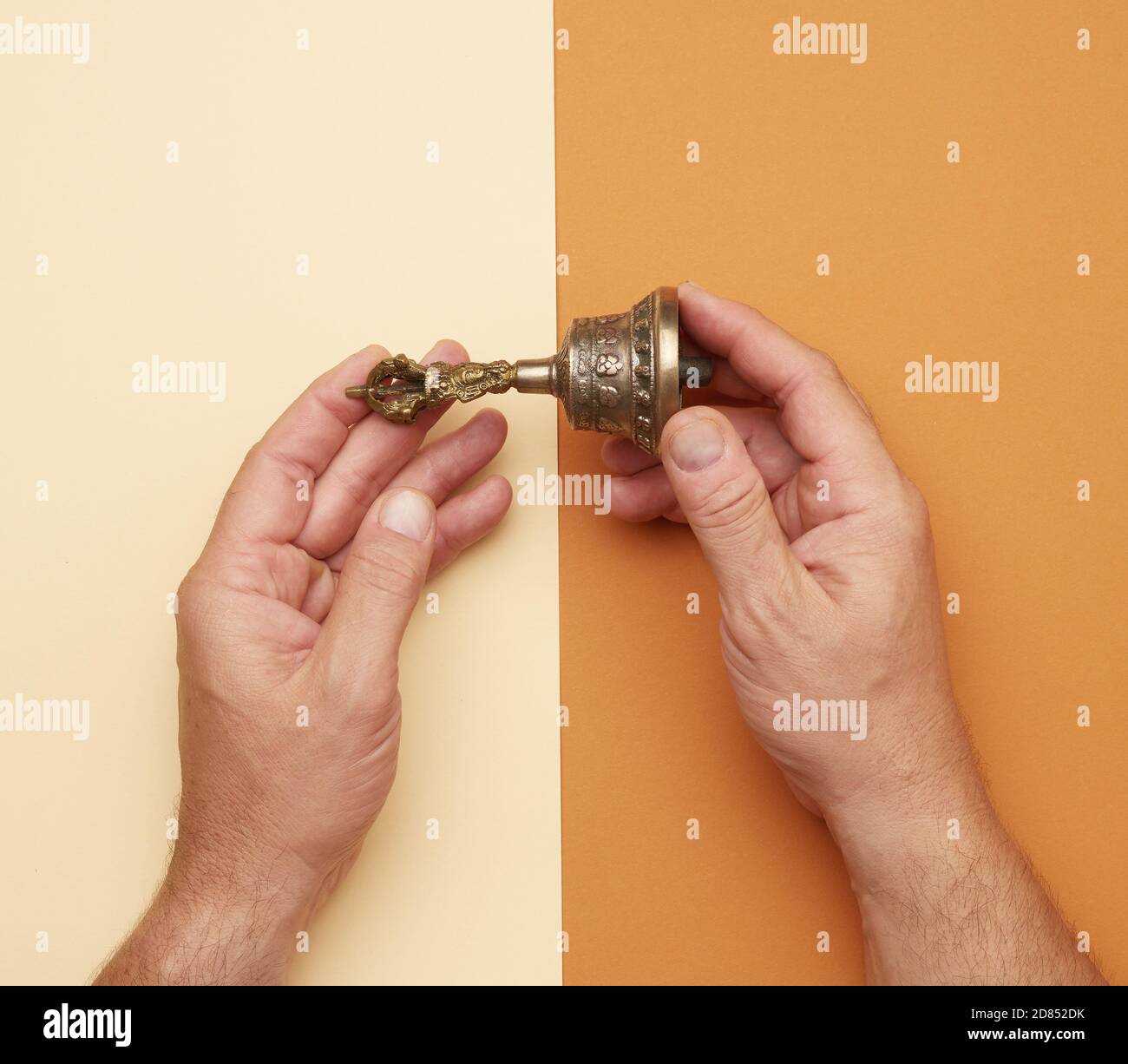 male hands hold a copper Tibetan ritual bell, bell represents the ...
