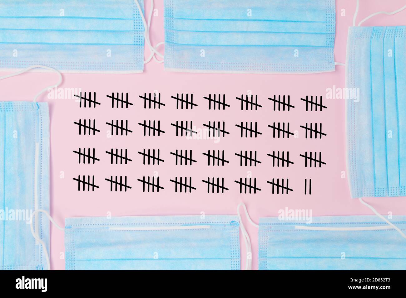 covid flat lay with medical mask and tally marks on pink background ...