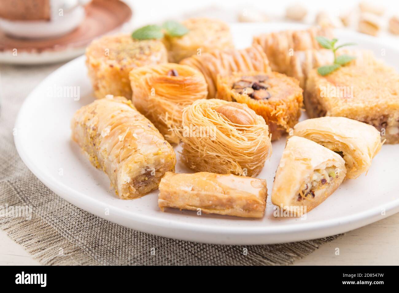 traditional arabic sweets (kunafa, baklava) and a cup of coffee on a ...