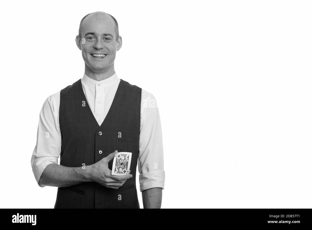 Happy bald Caucasian magician man smiling and bending Jack of Diamonds ...