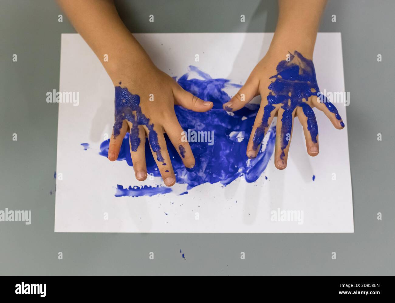children's hands are painted in blue paint. education, school concept ...