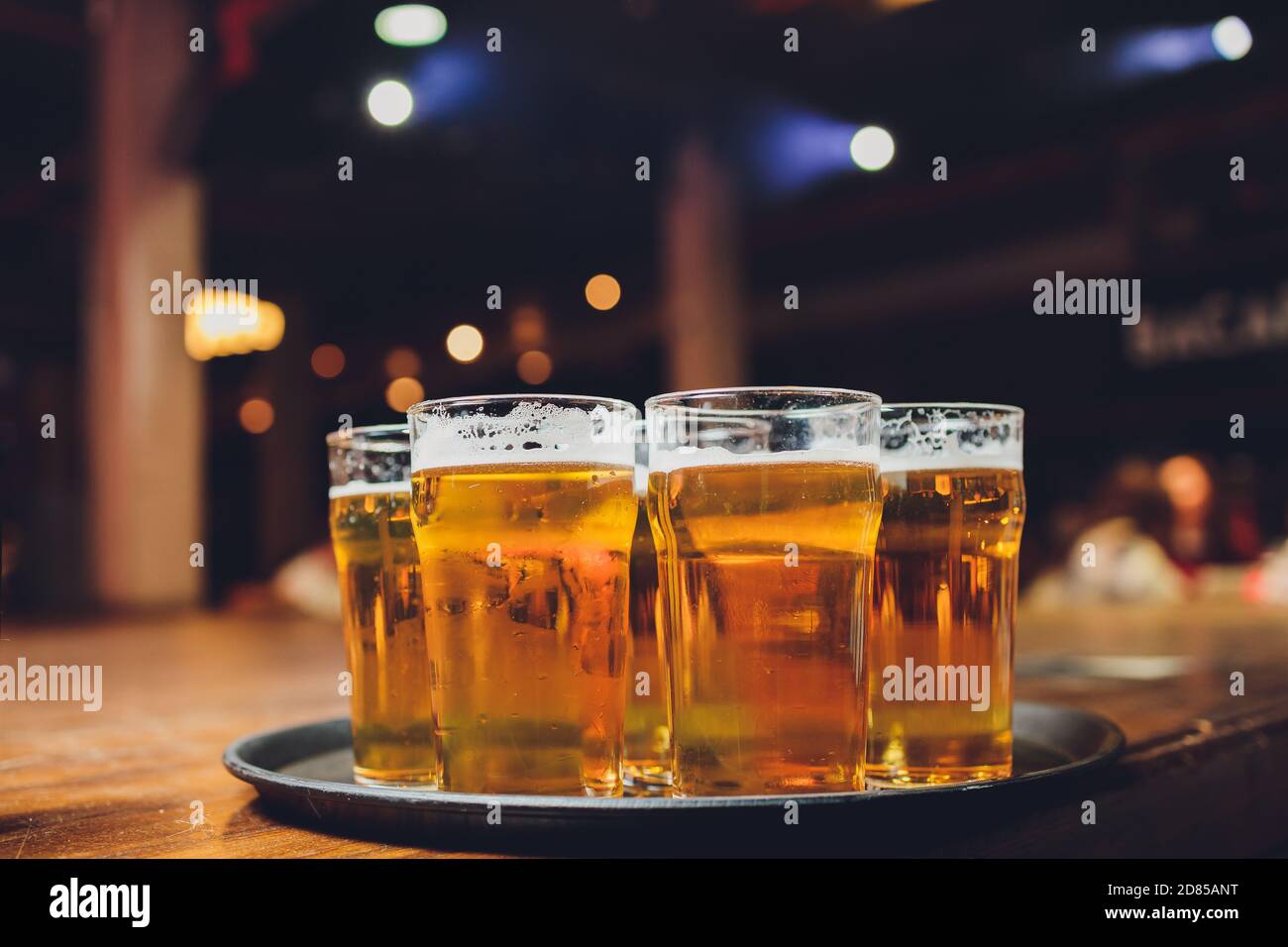 Waiter serving glasses of cold beer on the tray Stock Photo - Alamy