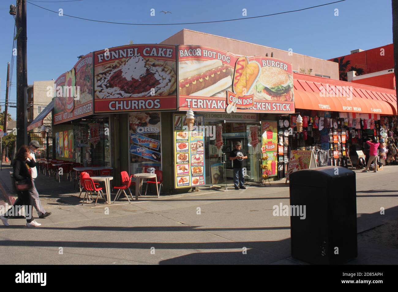 Several colorful snack shacks in a row offering different kinds of food ...