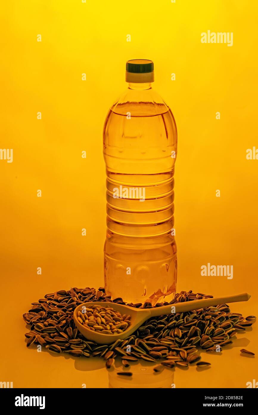 Sunflower oil in plastic bottle and seeds on yellow background Stock ...