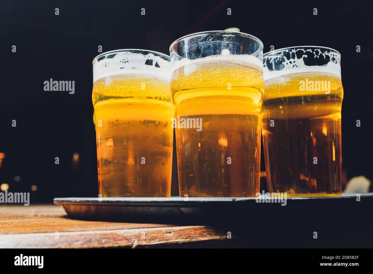 Waiter serving glasses of cold beer on the tray Stock Photo - Alamy