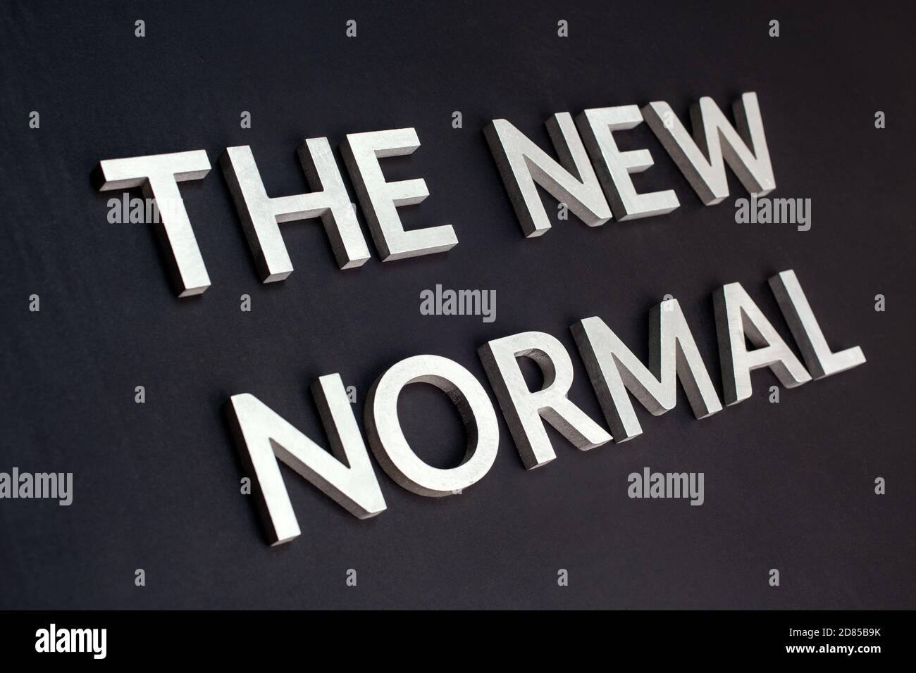 words the new normal on black surface in tilted linear perspective ...