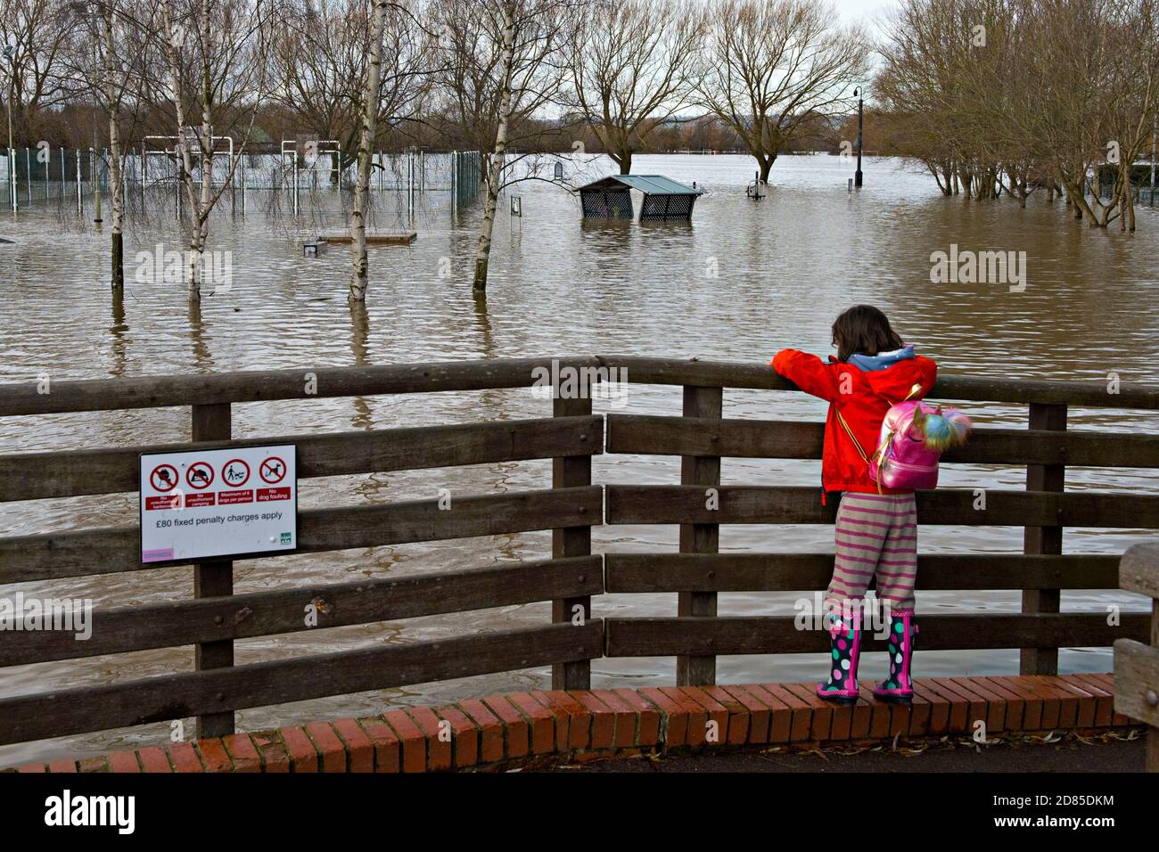 A child looks at the flooded sportsground in Tonbridge, Kent, UK ...