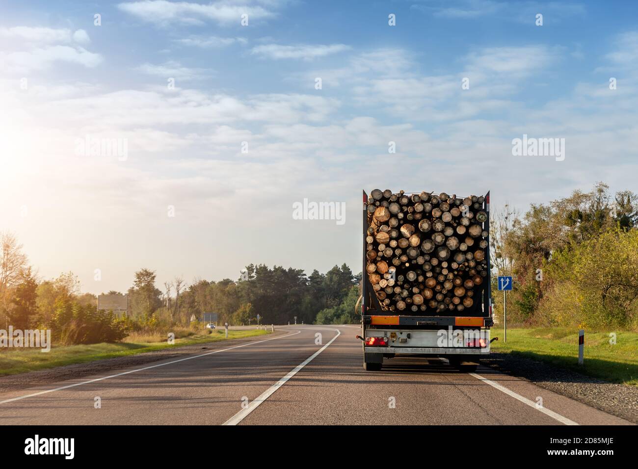back view of long heavy industrial wood carrier cargo vessel truck ...