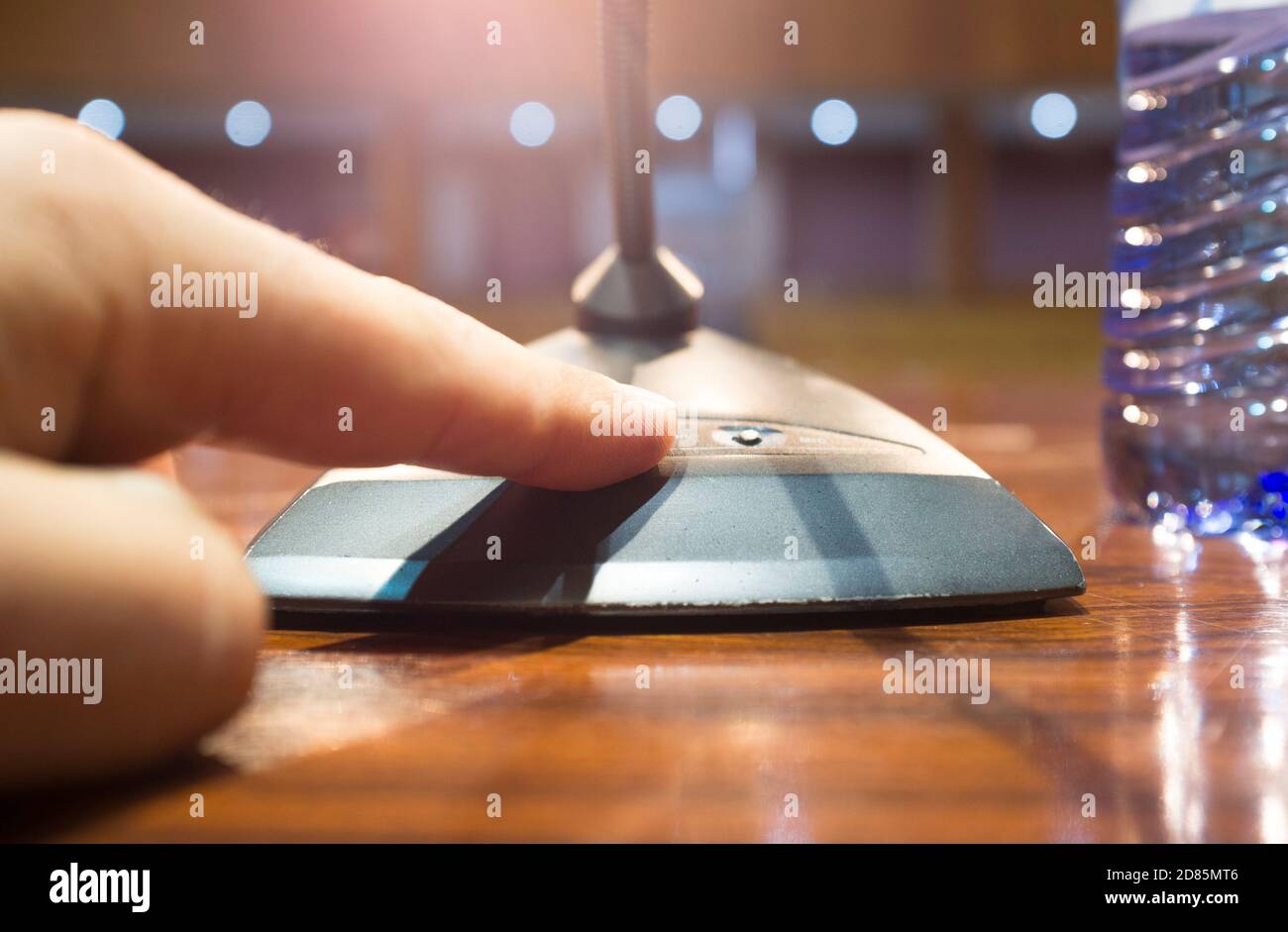 Speaker finger is about to press on-off button of a table conference ...