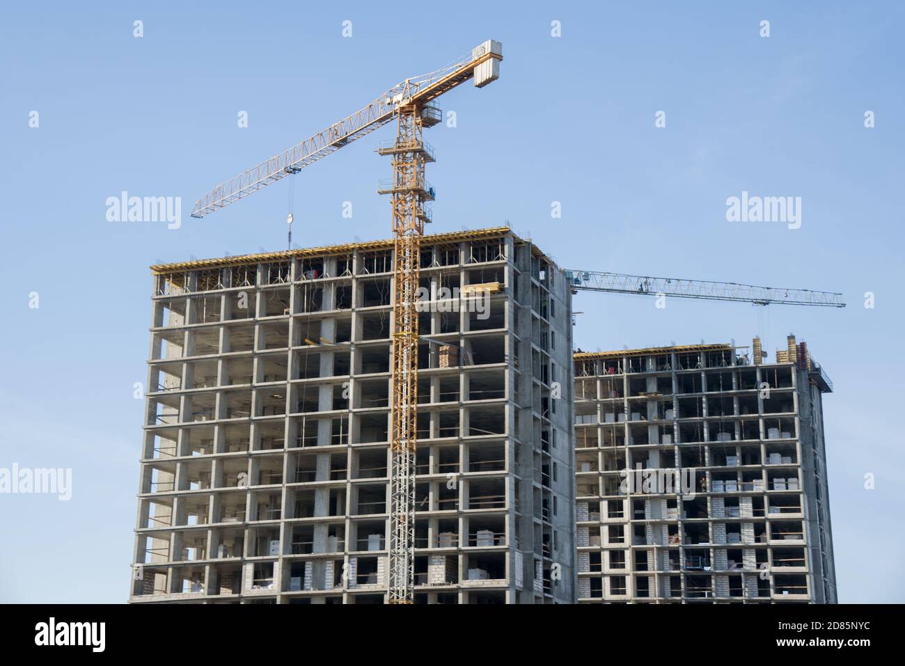 Hydraulic luffing jib tower cranes and workers being poured concrete ...