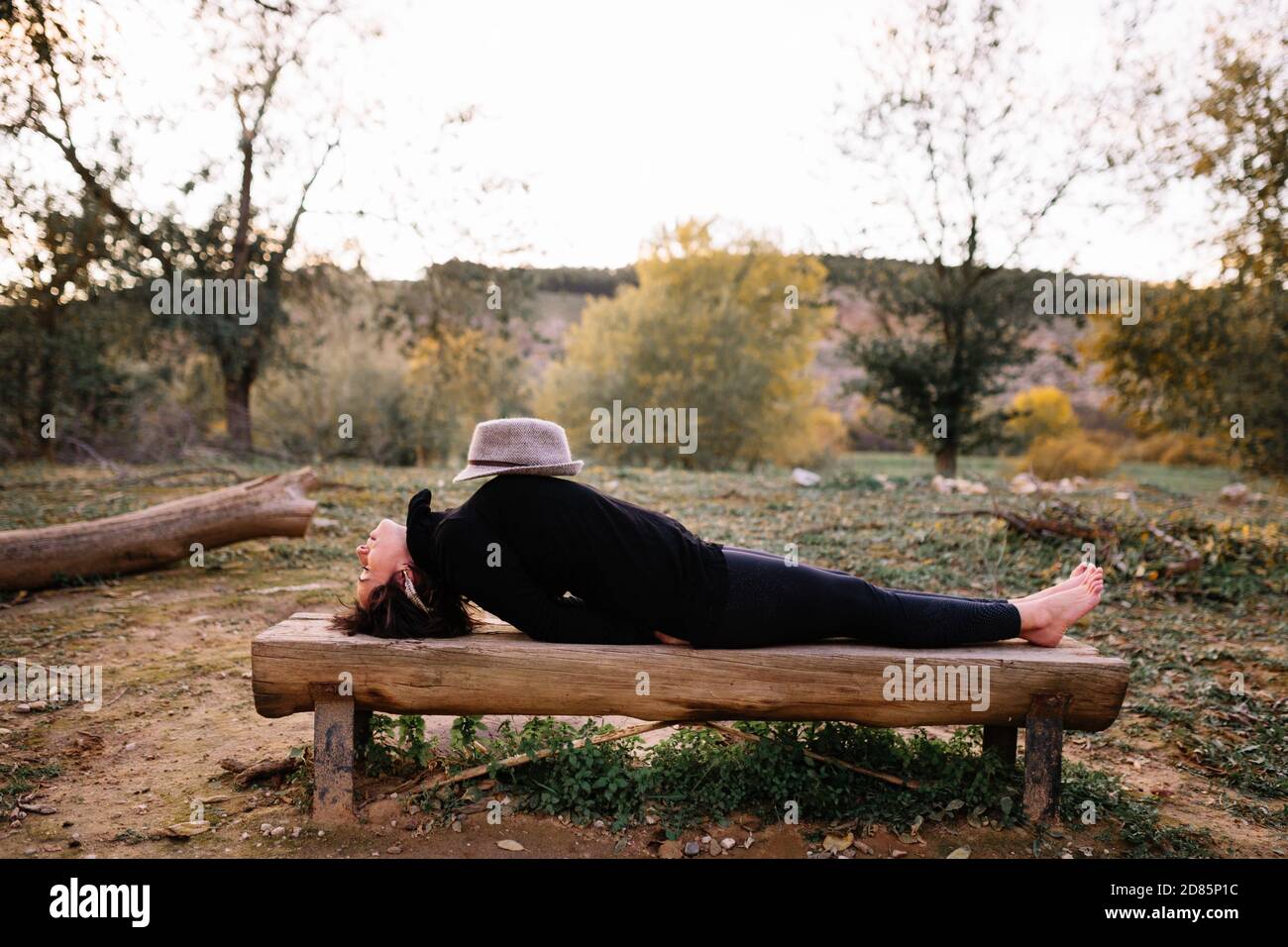 Woman practicing yoga and stretching lying down on a bench Stock Photo ...