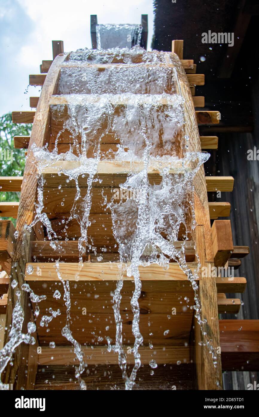 The mill wheel rotates under a stream of water, close up Stock Photo ...