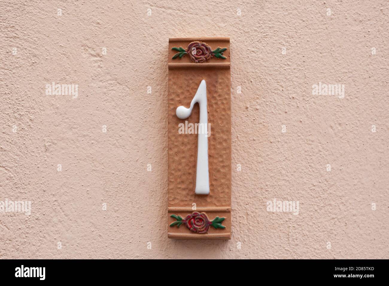 Sign with the house number 1 on the stone wall is pink Stock Photo - Alamy