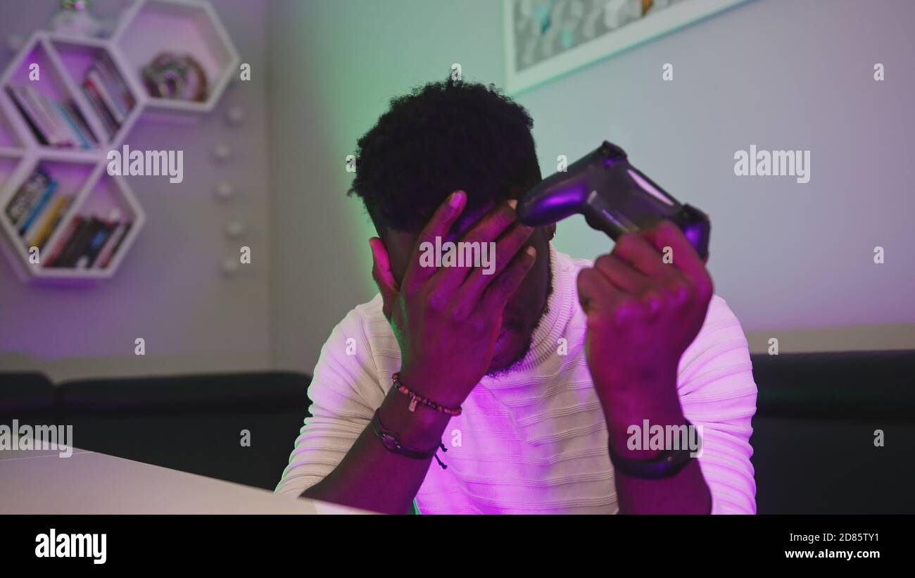 Black man playing game using console controlling joystick ...