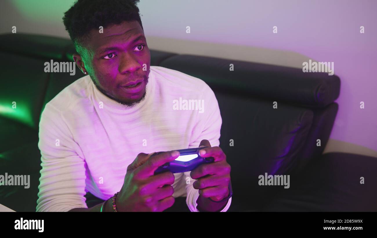Portrait of happy black man playing game using video game console ...