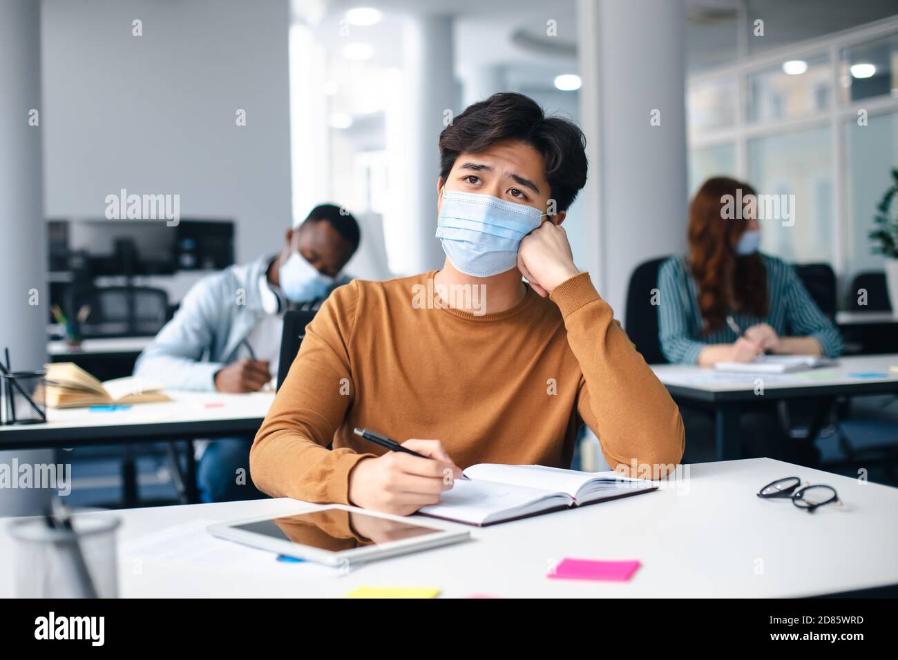 Asian male student in mask sitting at desk in class Stock Photo - Alamy