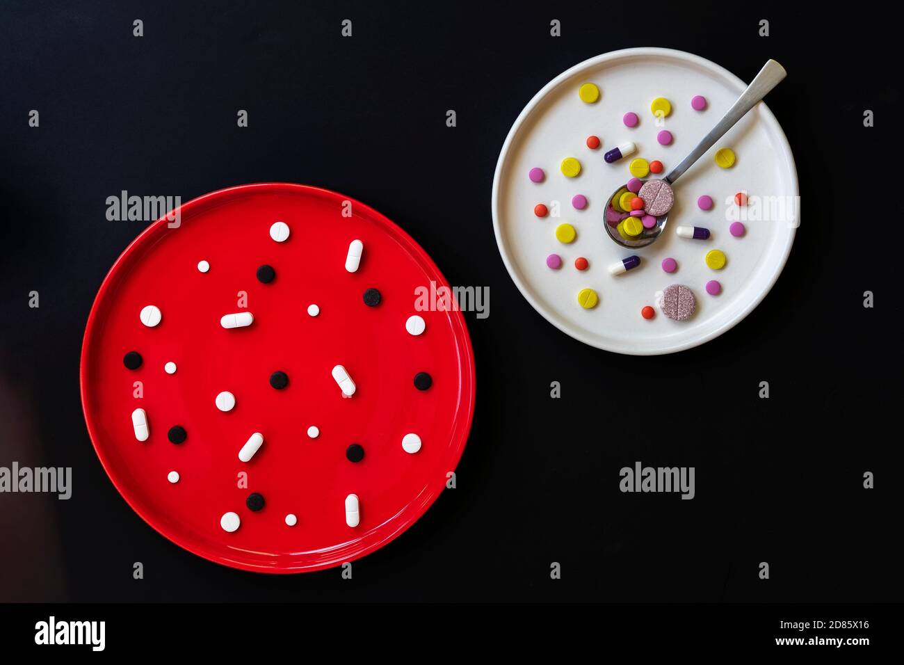Two plates with of colorful pills, concept of correct use of medicines ...
