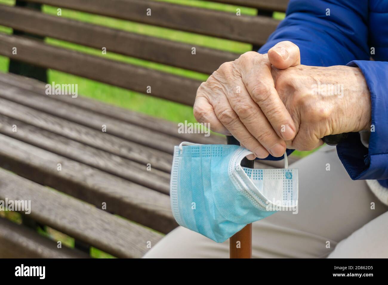 Old lady holding walking stick in park. Senior woman holding walking ...