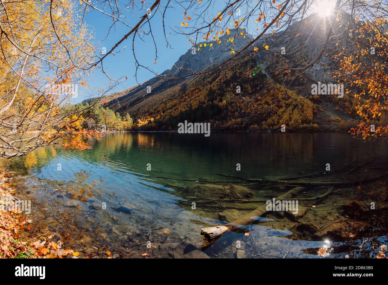 Mountain lake with transparent water and colorful autumnal trees ...