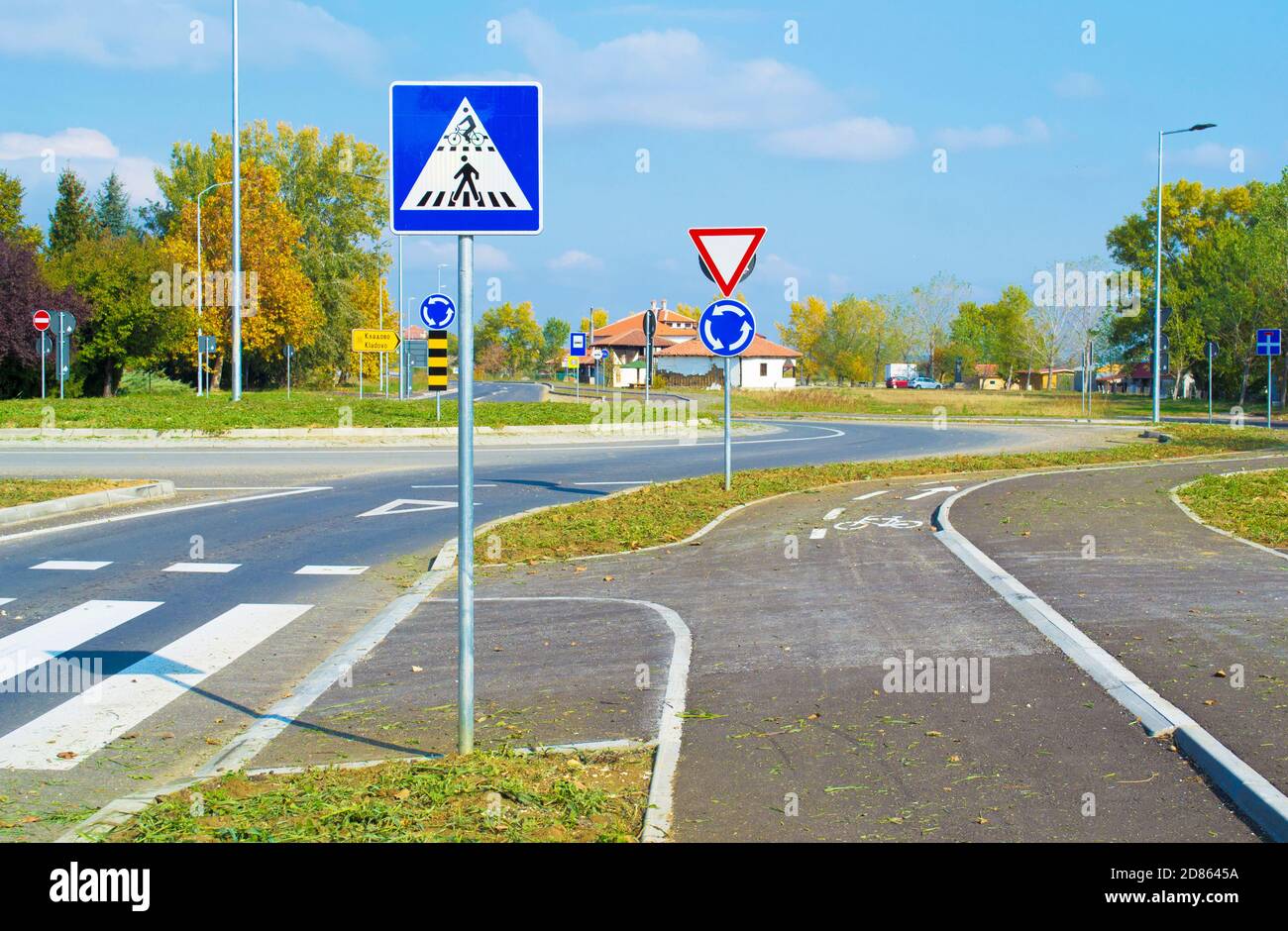 Road signs that shows crosswalk and cycle cross ahead of roundabout ...