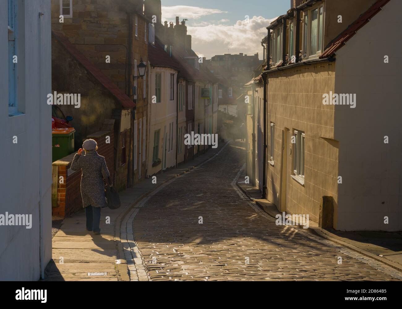 Woman walking down a backstreet in the old town at Whitby, North ...