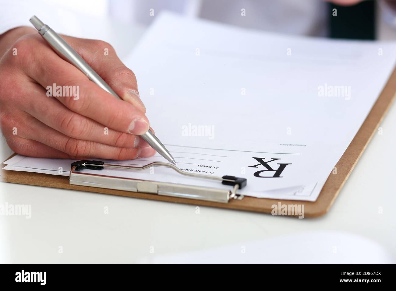 Male doctor hand write prescription at office worktable Stock Photo - Alamy