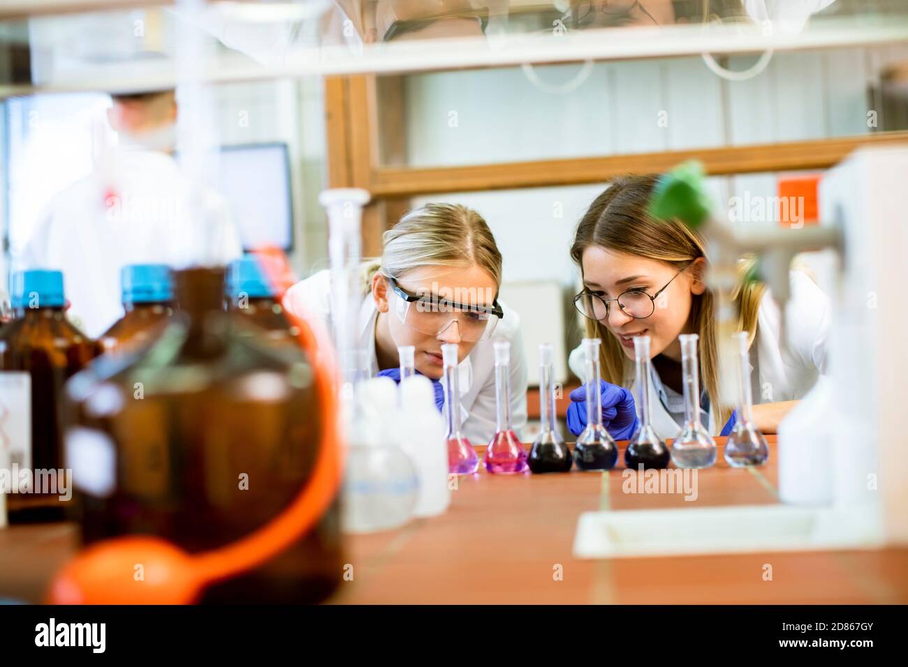 Cute female researchers in white lab coat working in the laboratory ...