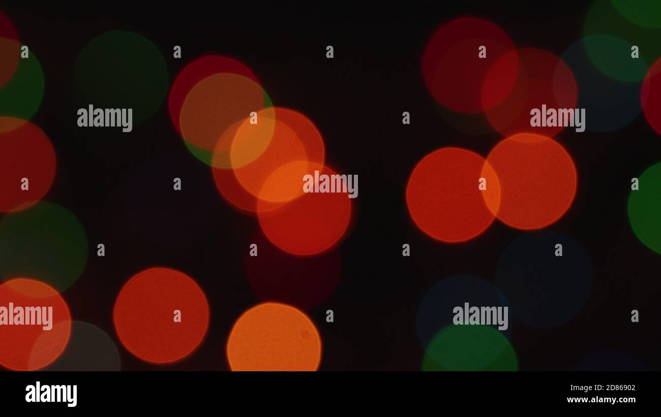 blurred dull Christmas lights light up slowly and fade out in dark deep ...