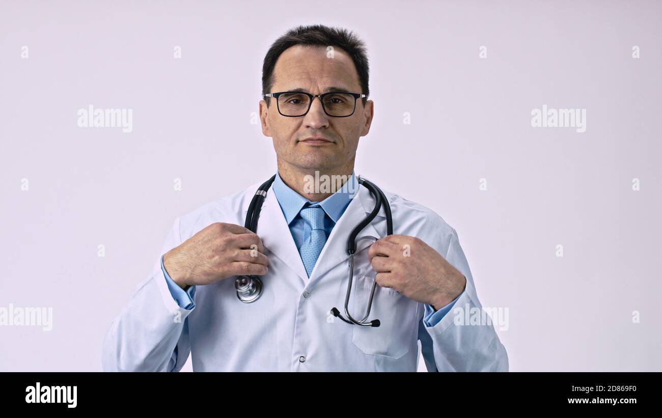 Handsome doc in lab coat puts on stethoscope examining patient white ...
