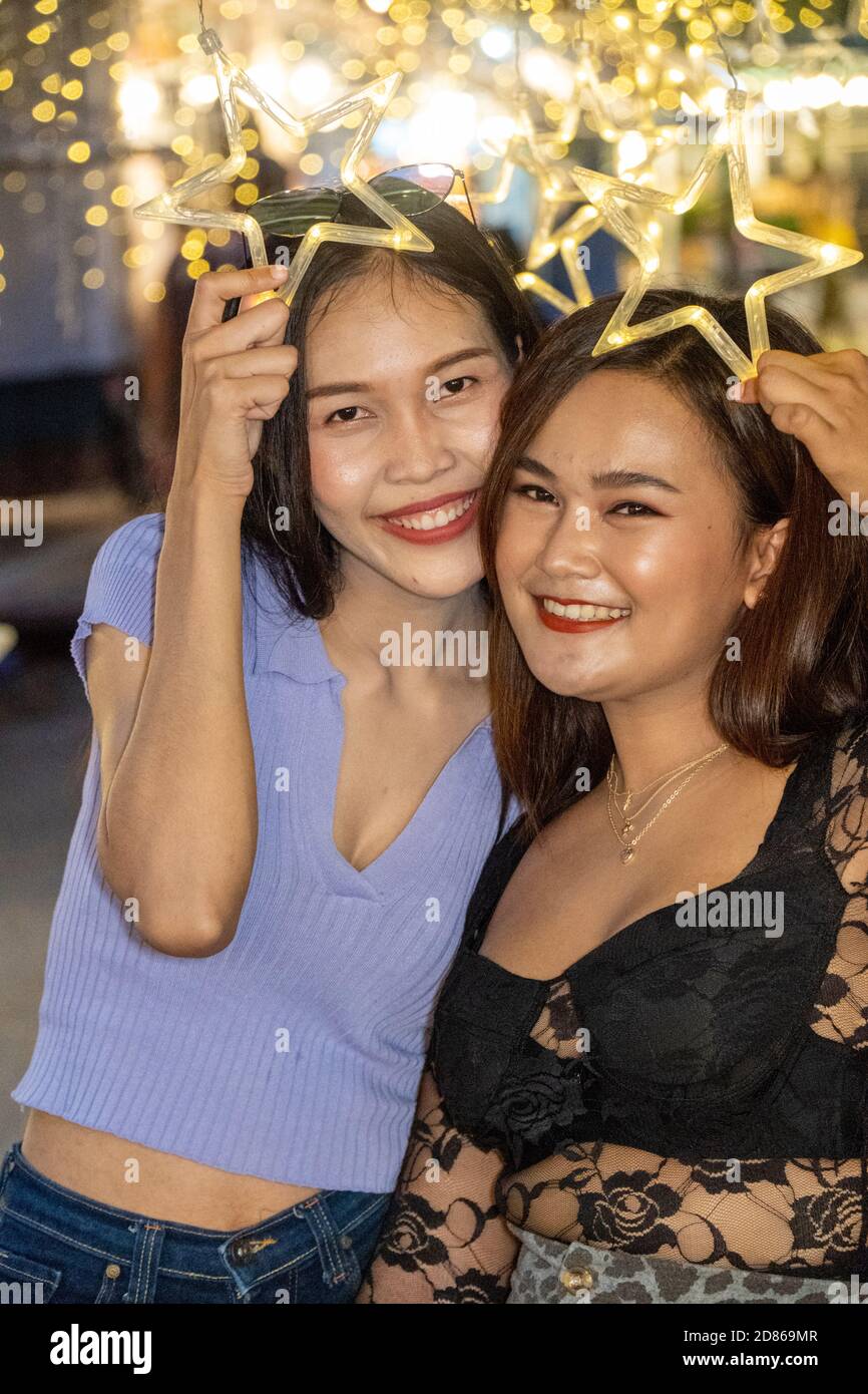 Two asian girls surrounded by lights Stock Photo - Alamy