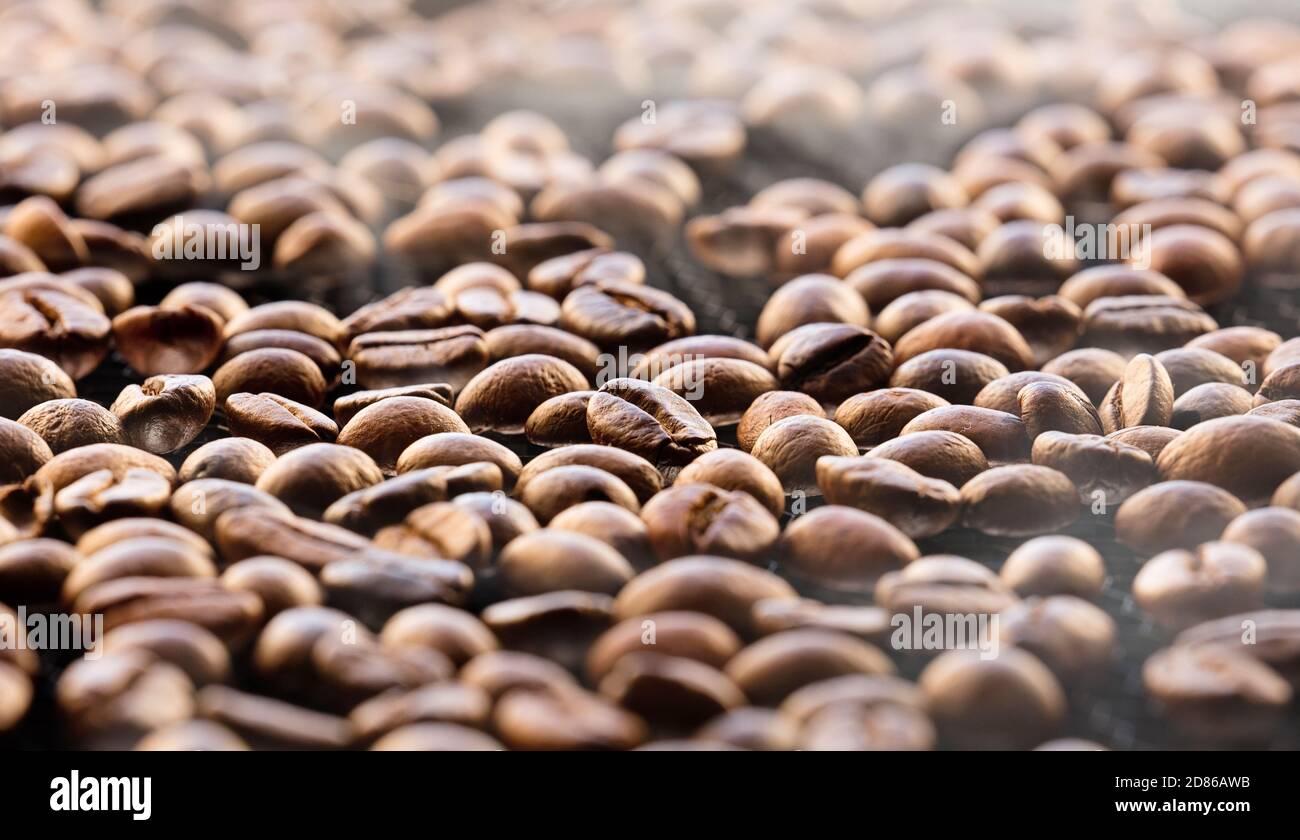 Broken coffee beans, background of roasting coffee beans with smoke ...