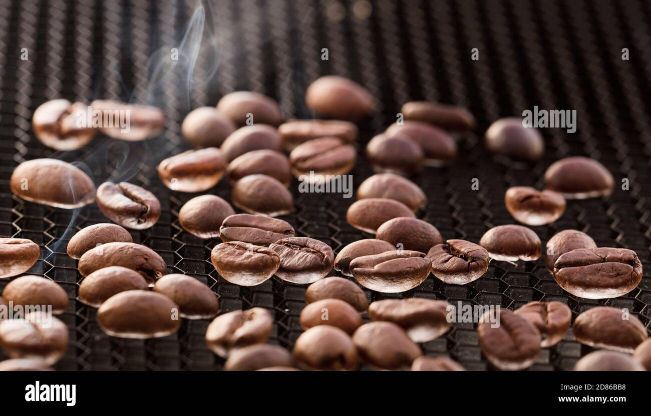 Broken coffee beans, background of roasting coffee beans with smoke ...