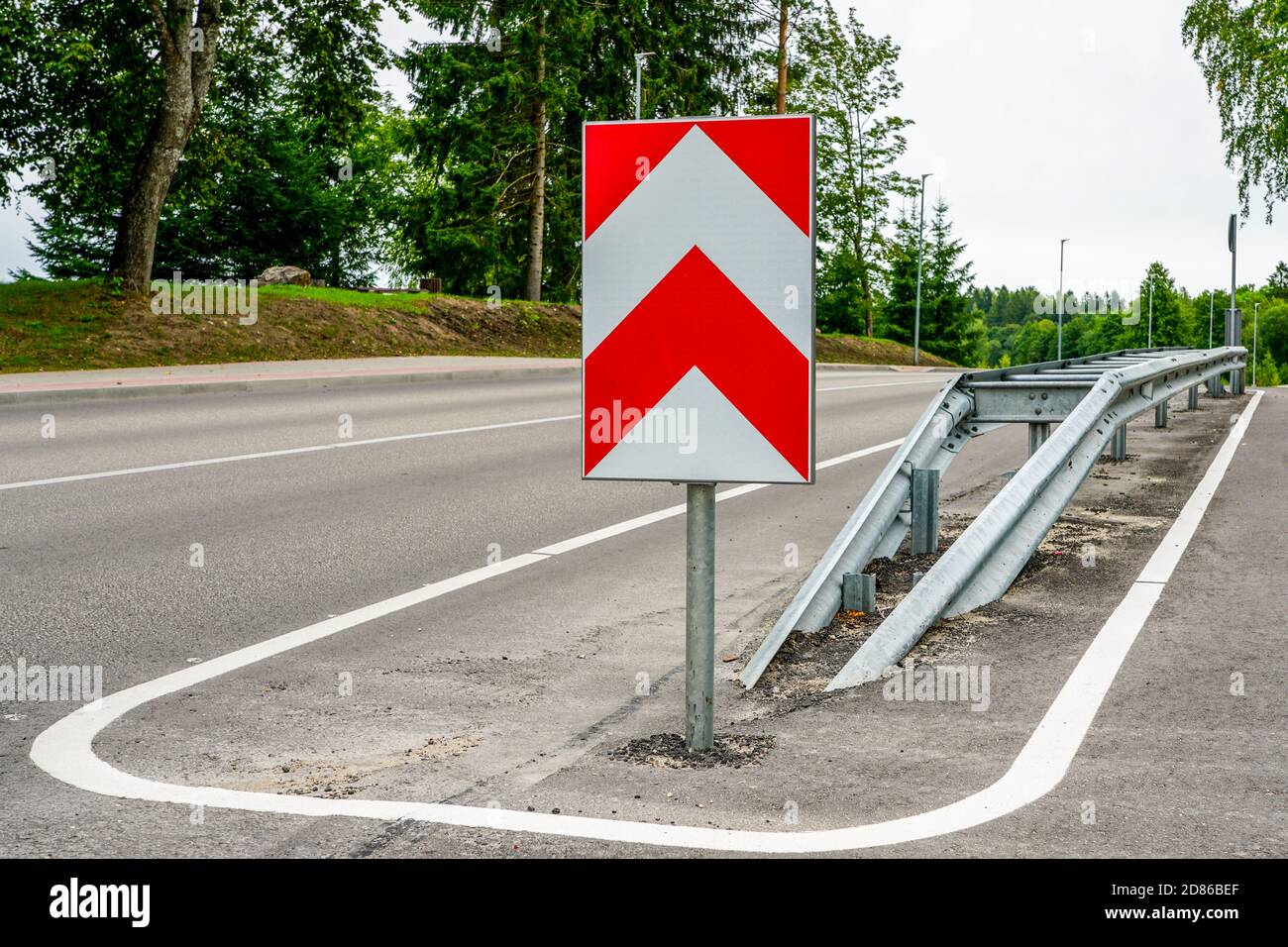 a metal safety barrier with a red and white striped traffic sign at the ...