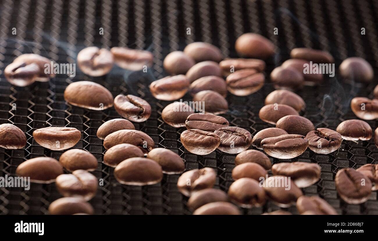 Broken coffee beans, background of roasting coffee beans with smoke ...