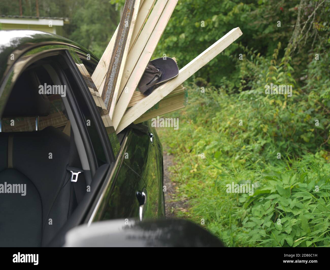 A car with long planks sticking out of the window, outdoor shot Stock ...